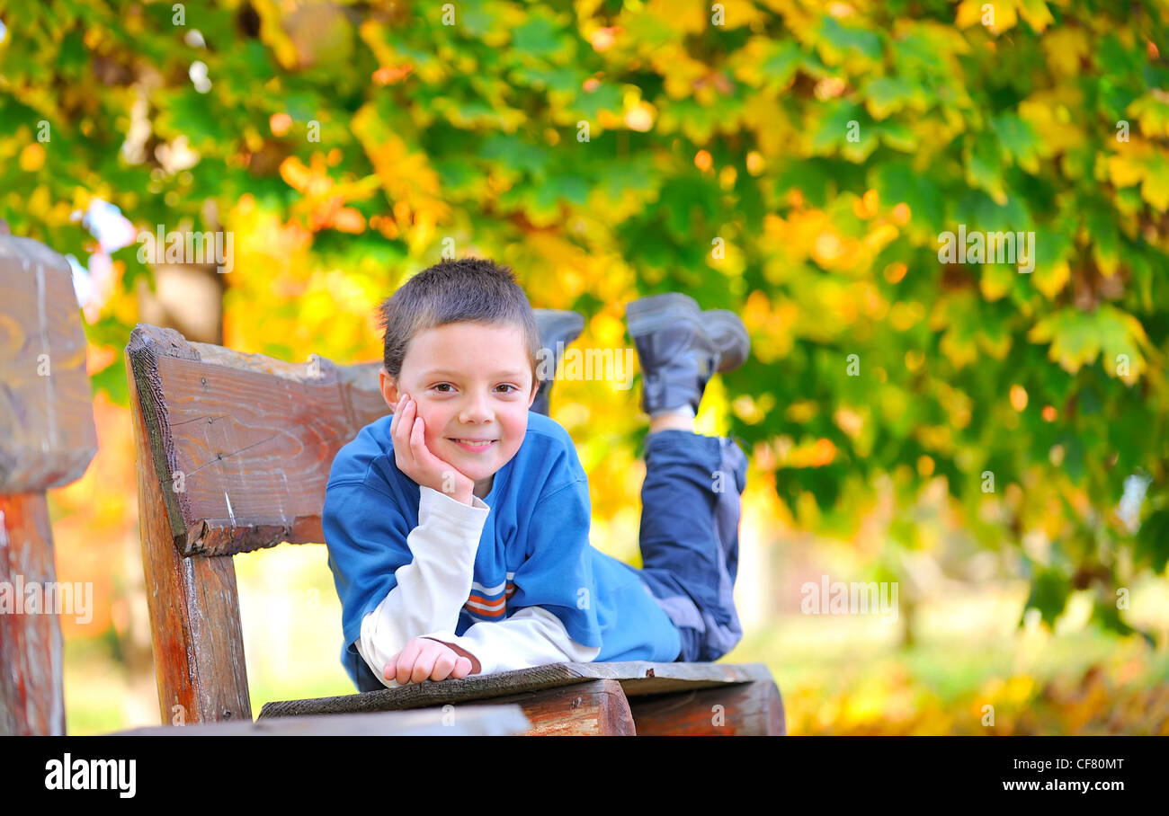 boy laying down on a bench Stock Photo - Alamy