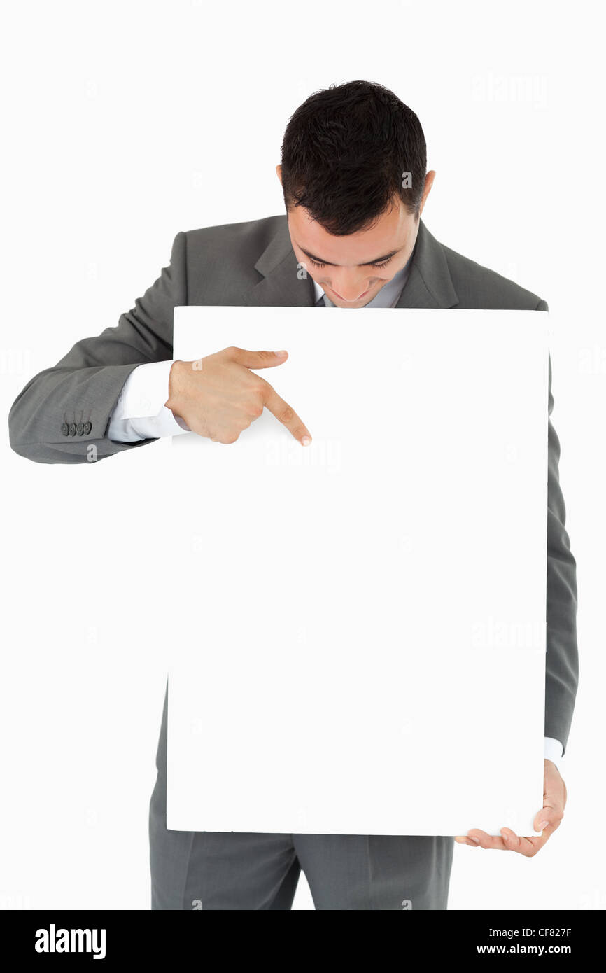 Businessman pointing at sign he is presenting Stock Photo - Alamy