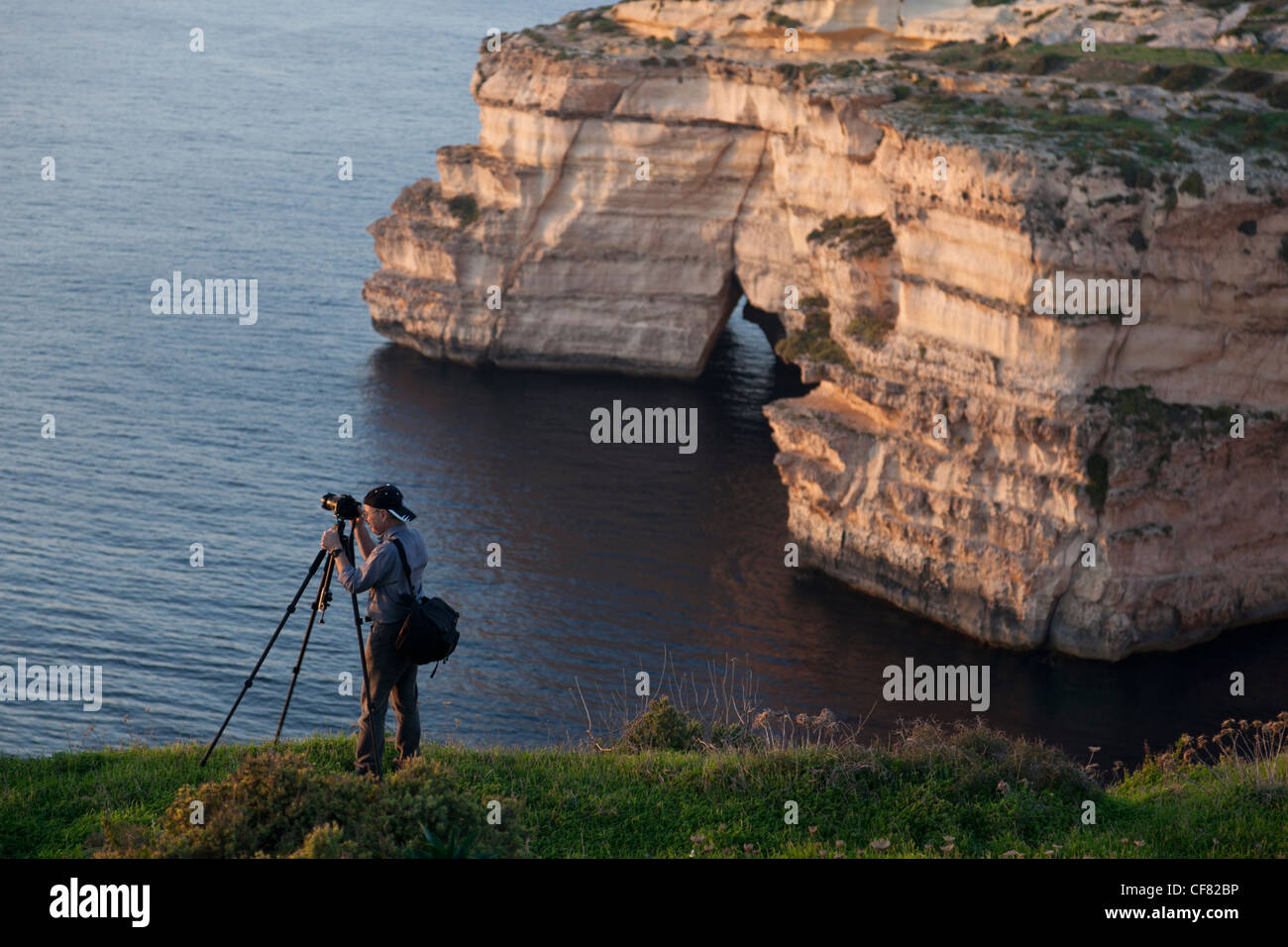 A photographer taking pictures of cliff scenery and sunset at the ...