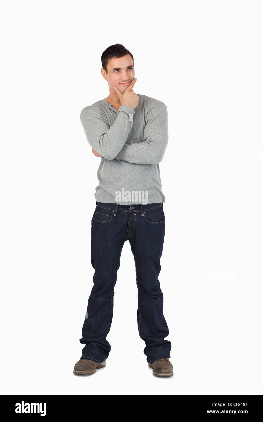 Young male standing and thinking Stock Photo - Alamy