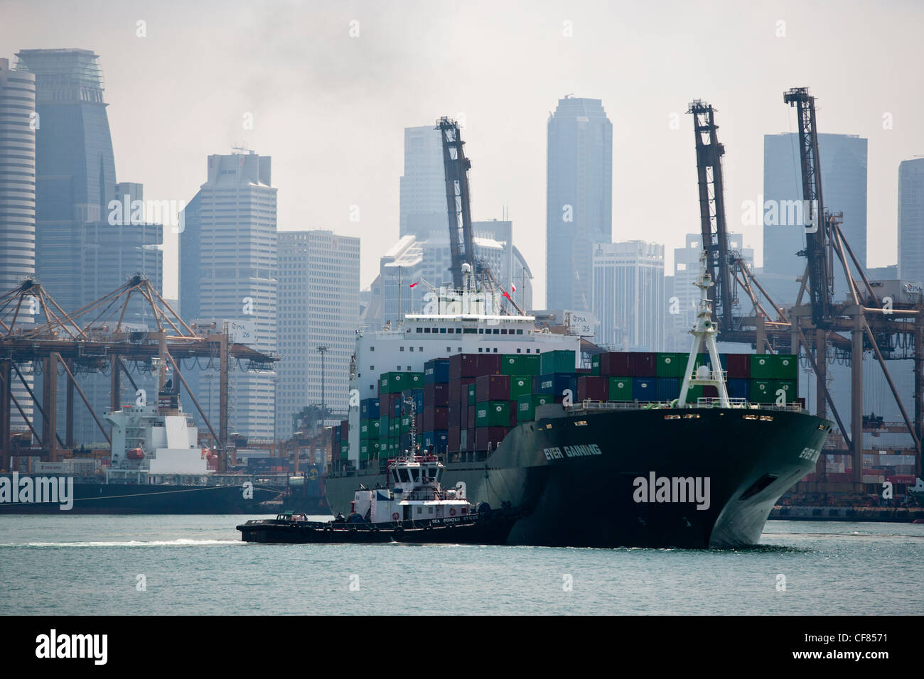 A container ship is maneuvered into position at the Brani terminal of ...