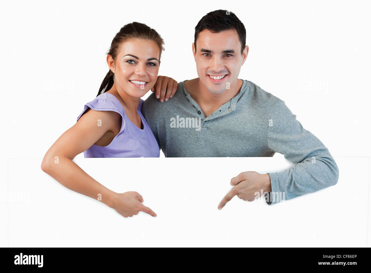 Young couple pointing at advertisement below them Stock Photo - Alamy