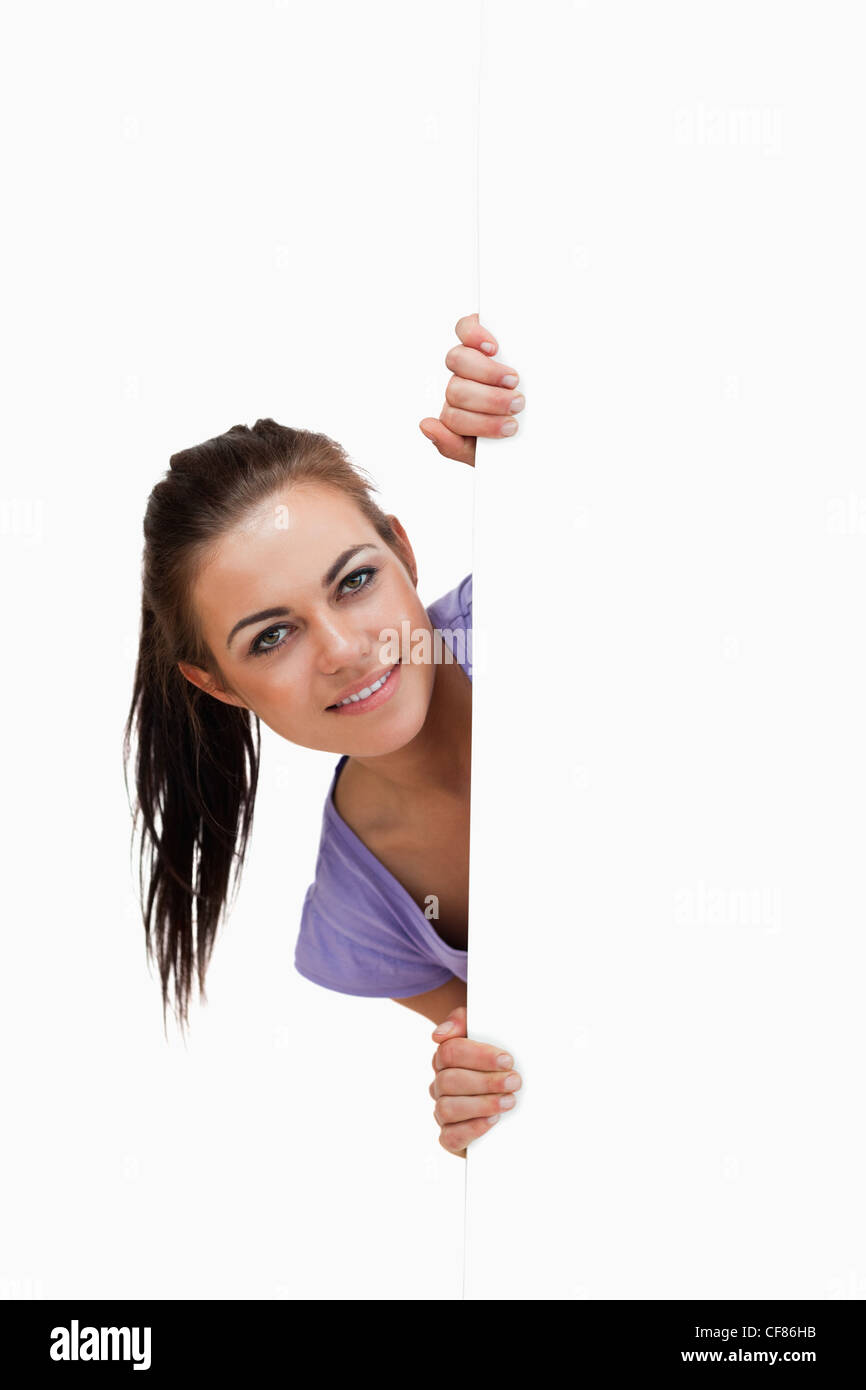 Young female looking around the corner Stock Photo - Alamy