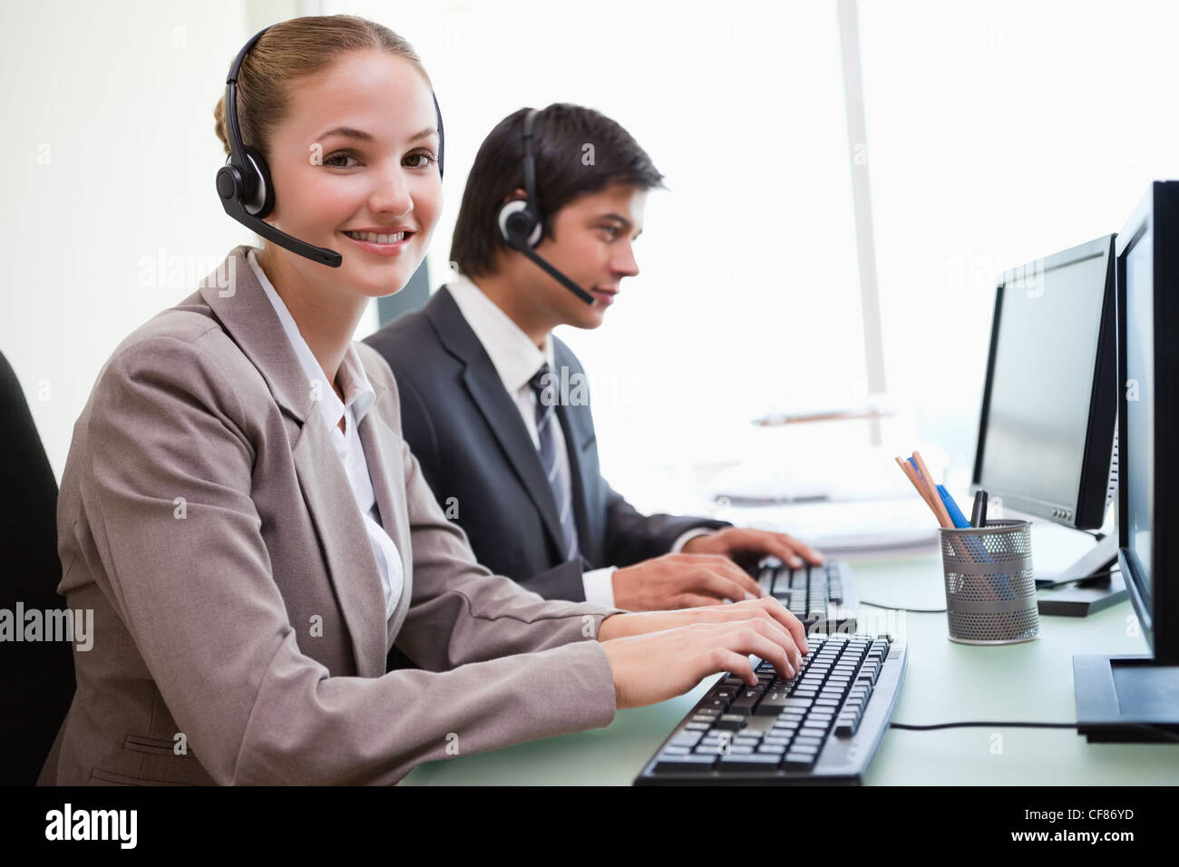 Smiling office workers using computers Stock Photo - Alamy