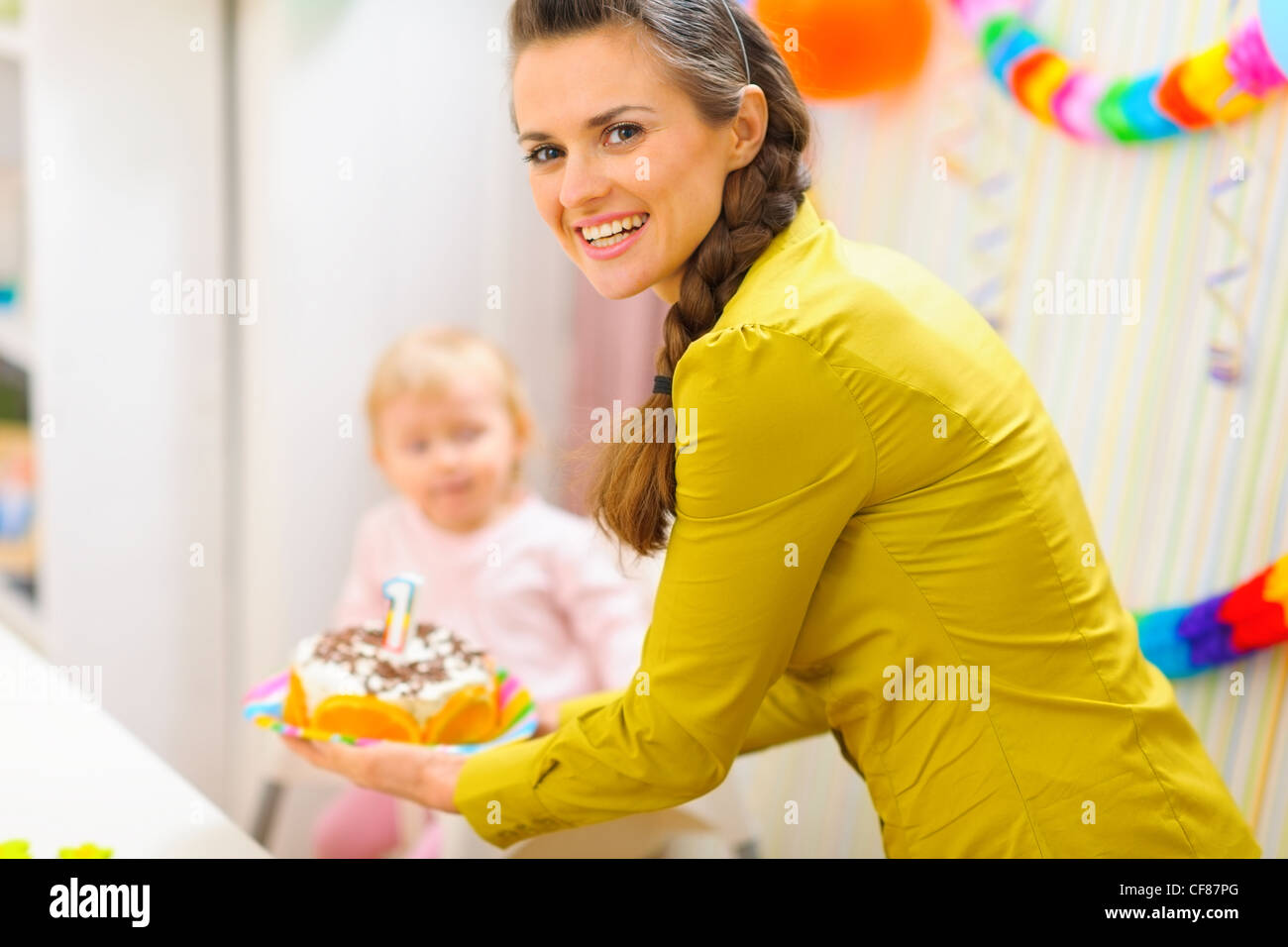 Happy mom carries birthday cake for baby Stock Photo - Alamy