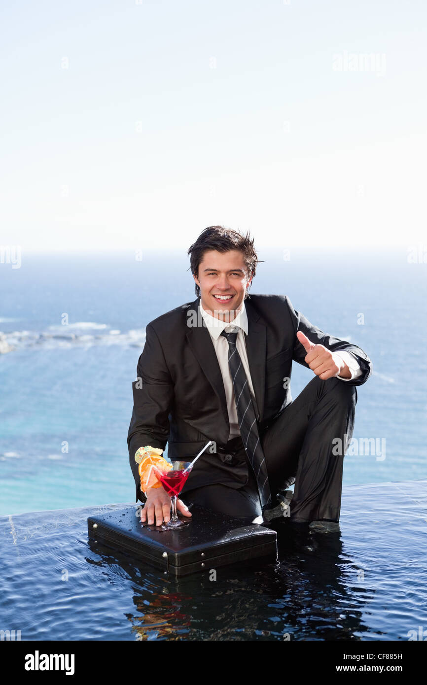 Portrait of a businessman posing with a cocktail on a briefcase Stock ...