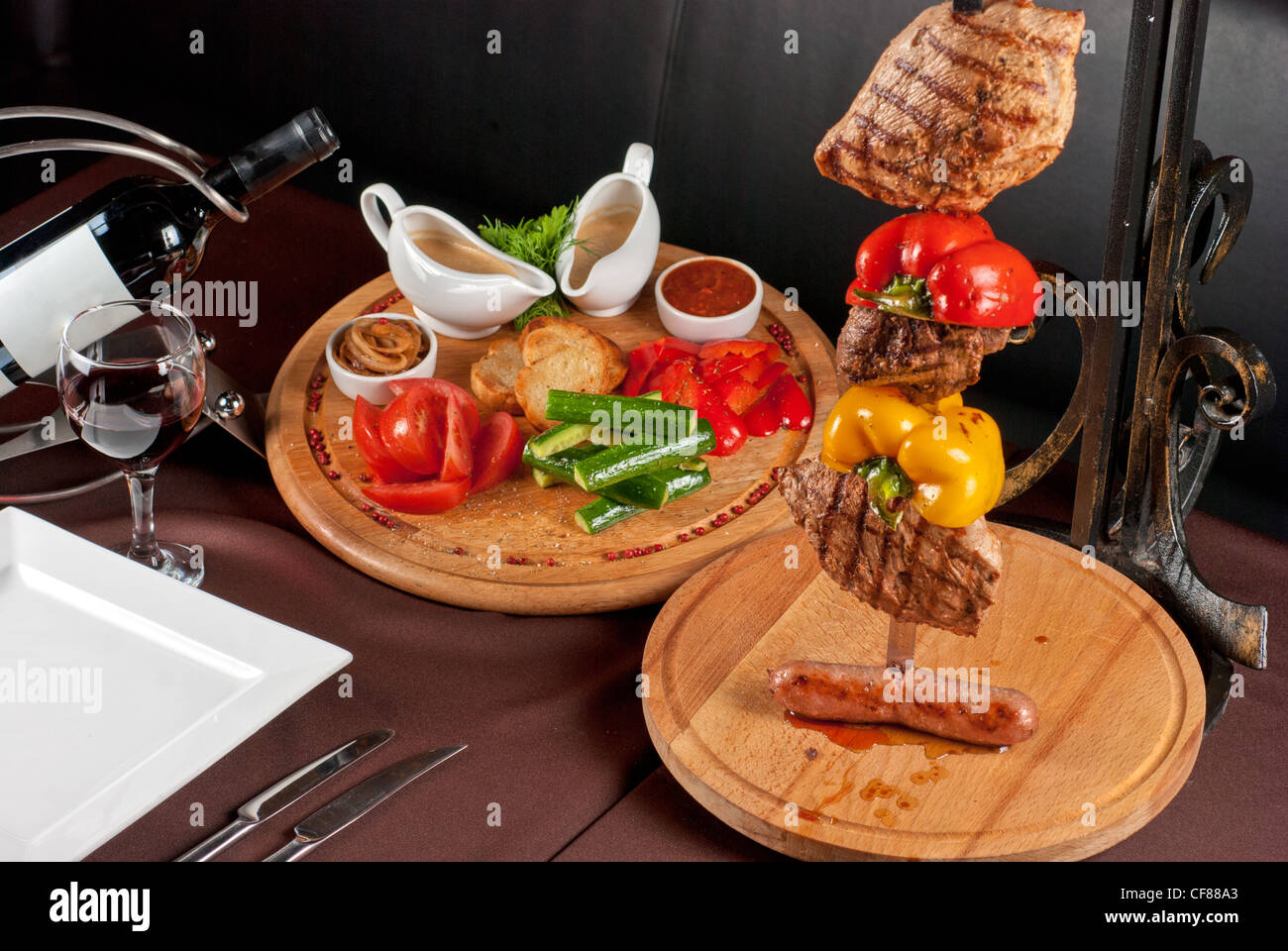 Big tasty roasted meat cuts at skewer on a decorated table Stock Photo ...