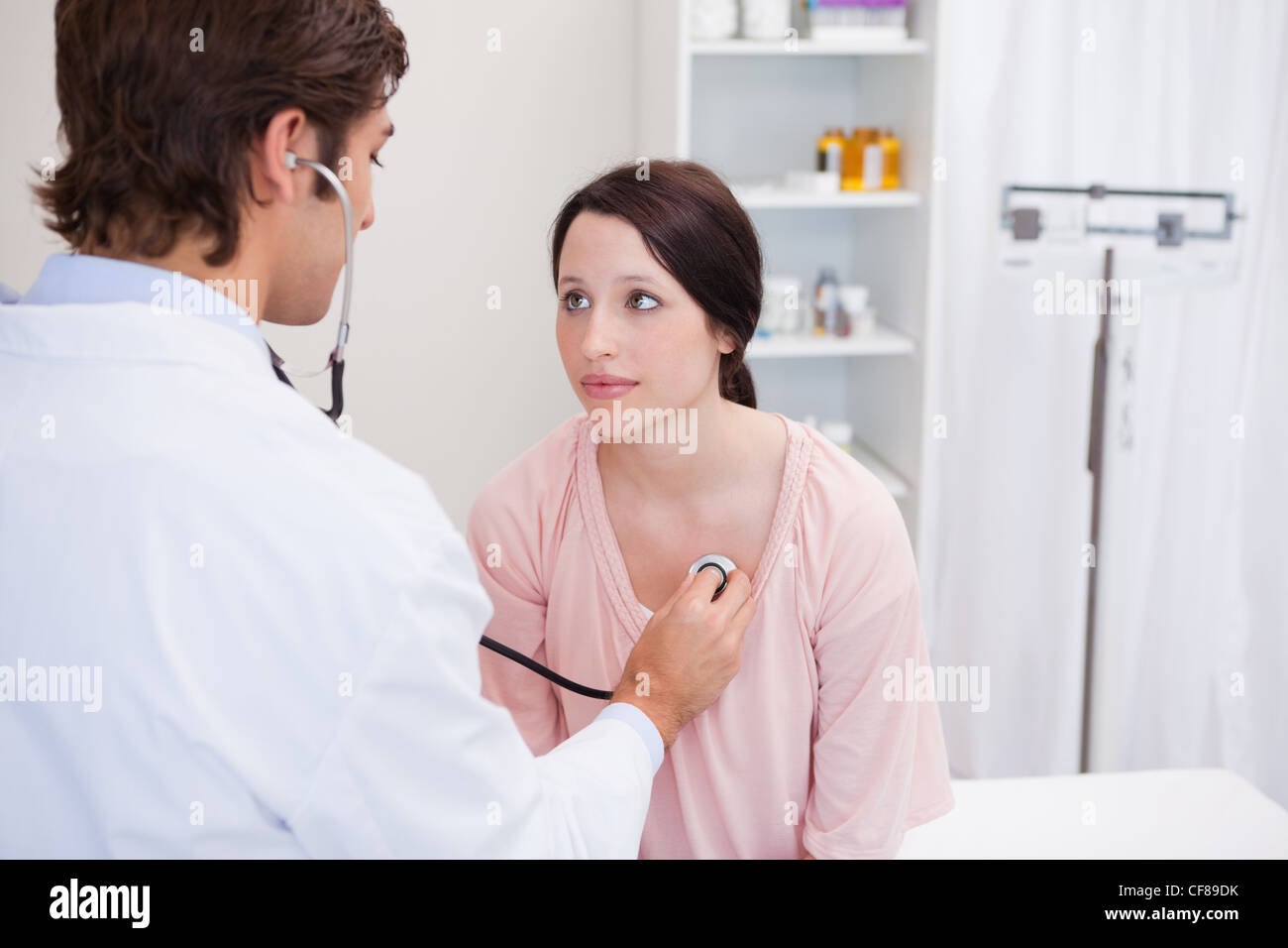 Young doctor taking his patients heart beat Stock Photo - Alamy