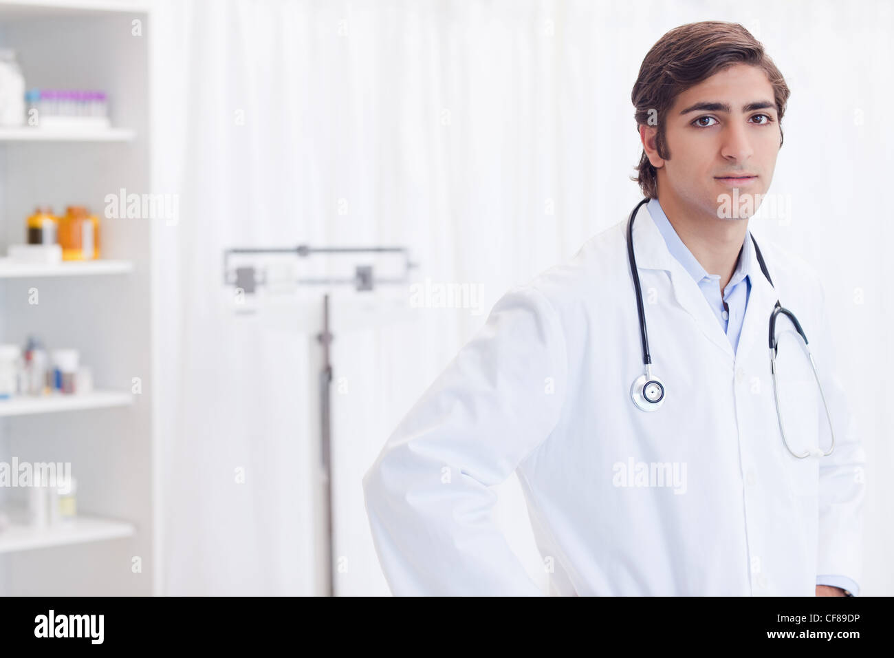 Young doctor standing in his examination room Stock Photo - Alamy