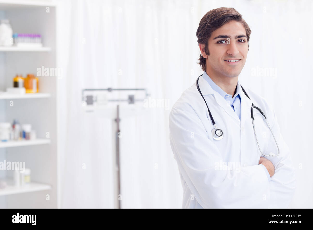 Smiling doctor standing in examination room Stock Photo - Alamy