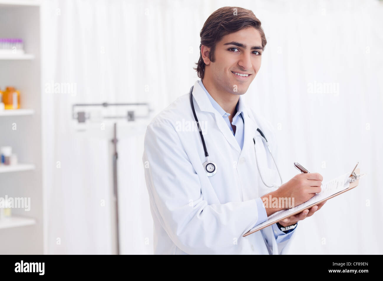 Side view of smiling doctor taking notes Stock Photo - Alamy