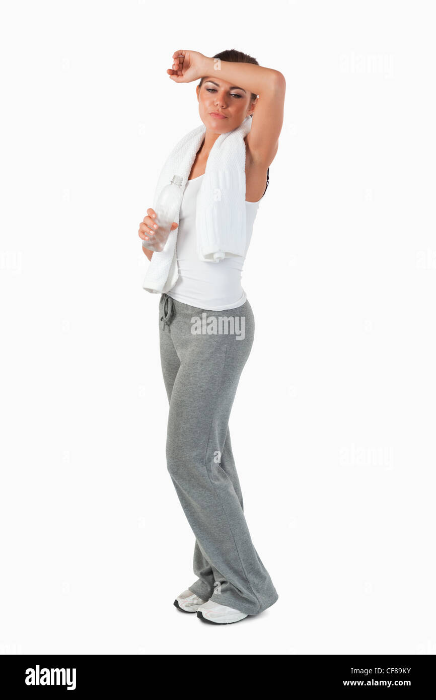 Side view of young woman wiping off sweat from her forehead Stock Photo ...