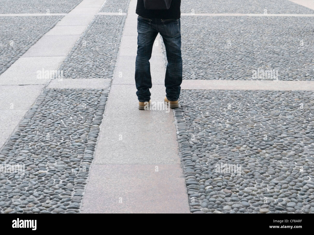 man standing in cobbled square Stock Photo - Alamy