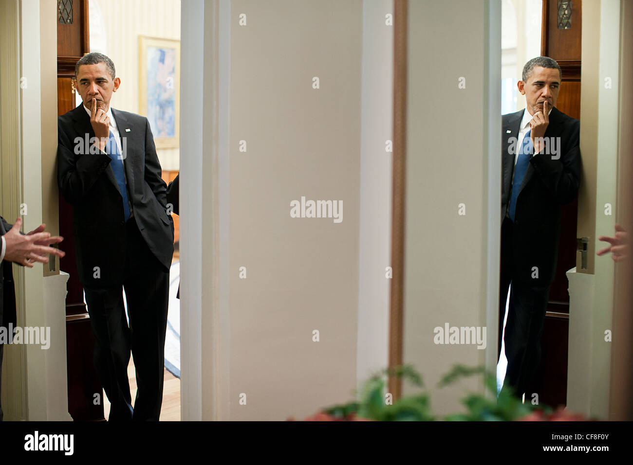 President Barack Obama is reflected in a mirror in the Outer Oval ...
