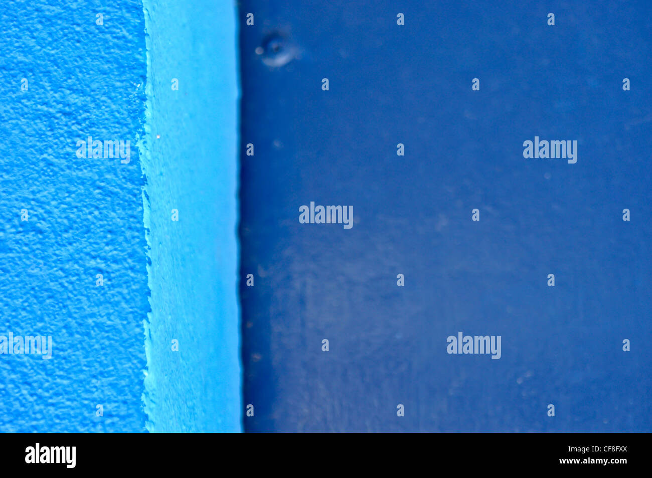 Close up of an outdoor concrete wall painted in three shades of blue ...