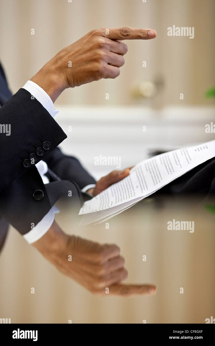 President Barack Obama hand is reflected on his desk as he gestures ...