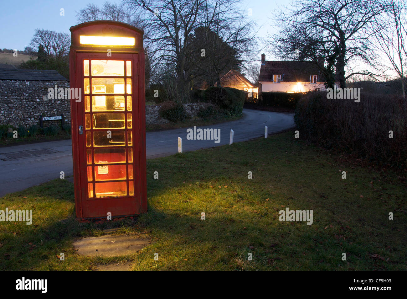 The light from a traditional red telephone box illuminates a dark and ...