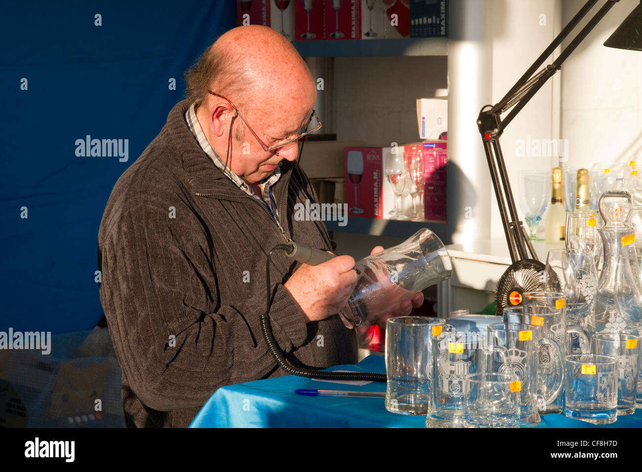 Man craftsman writing engraving on glasses Stock Photo - Alamy