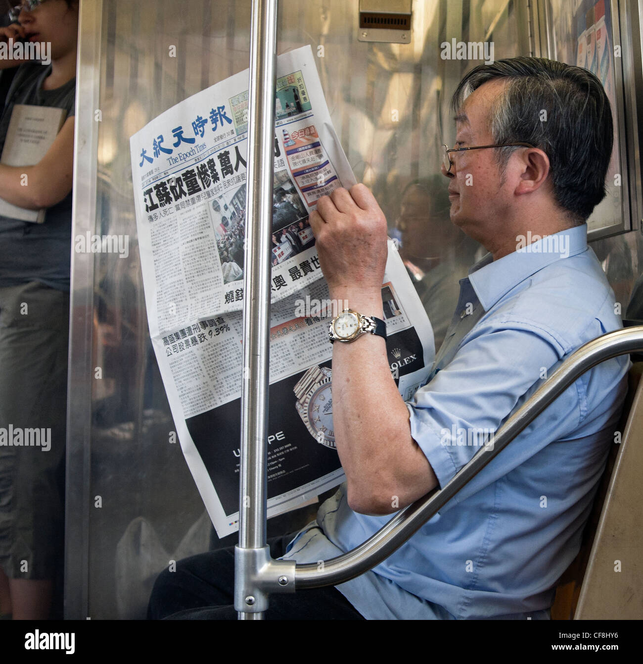 A man on a NYC subway reads a Chinese language newspaper Stock Photo ...