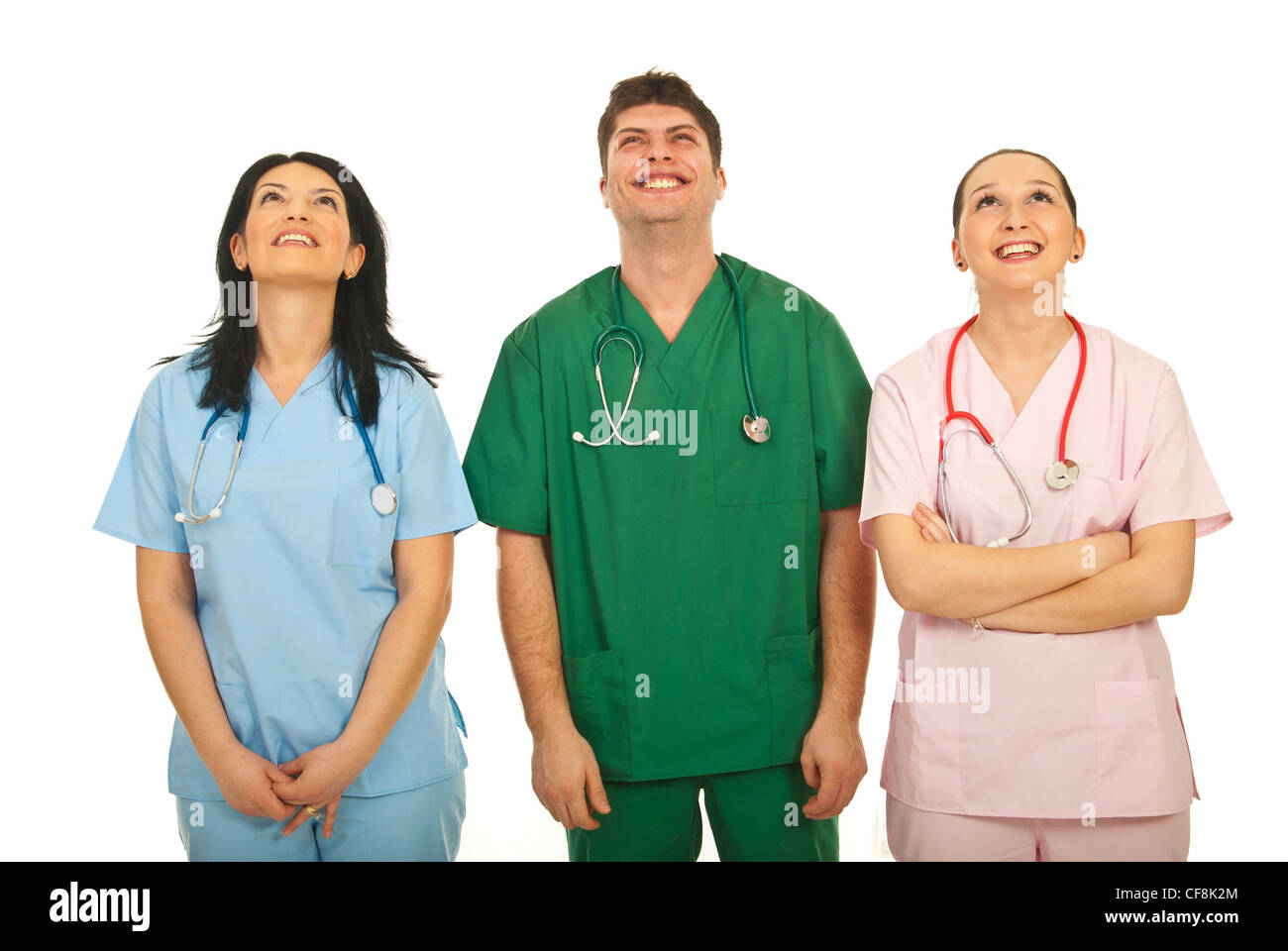 Laughing three doctors looking up and standing in a row isolated on ...