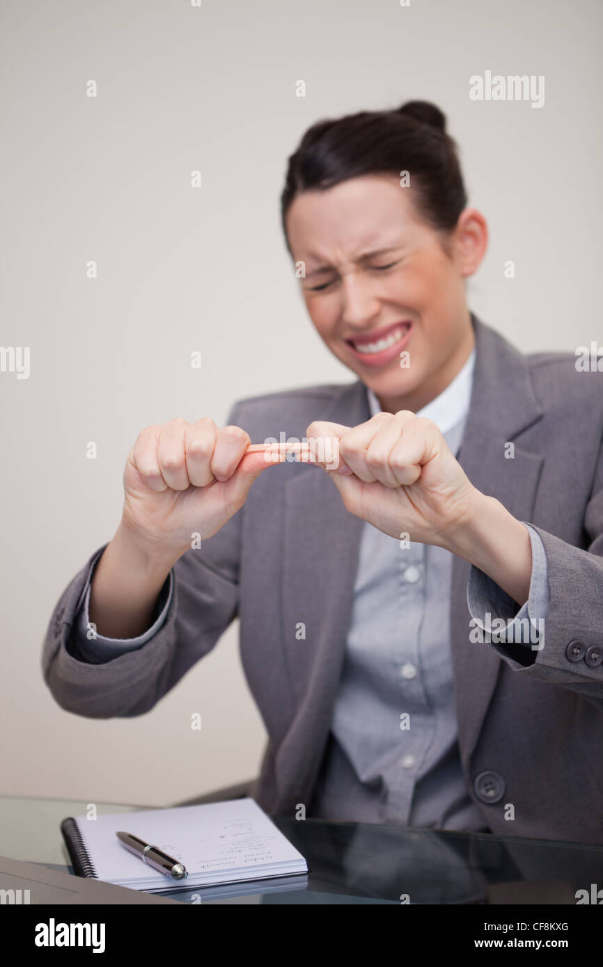 Angry businesswoman trying to break pencil Stock Photo - Alamy