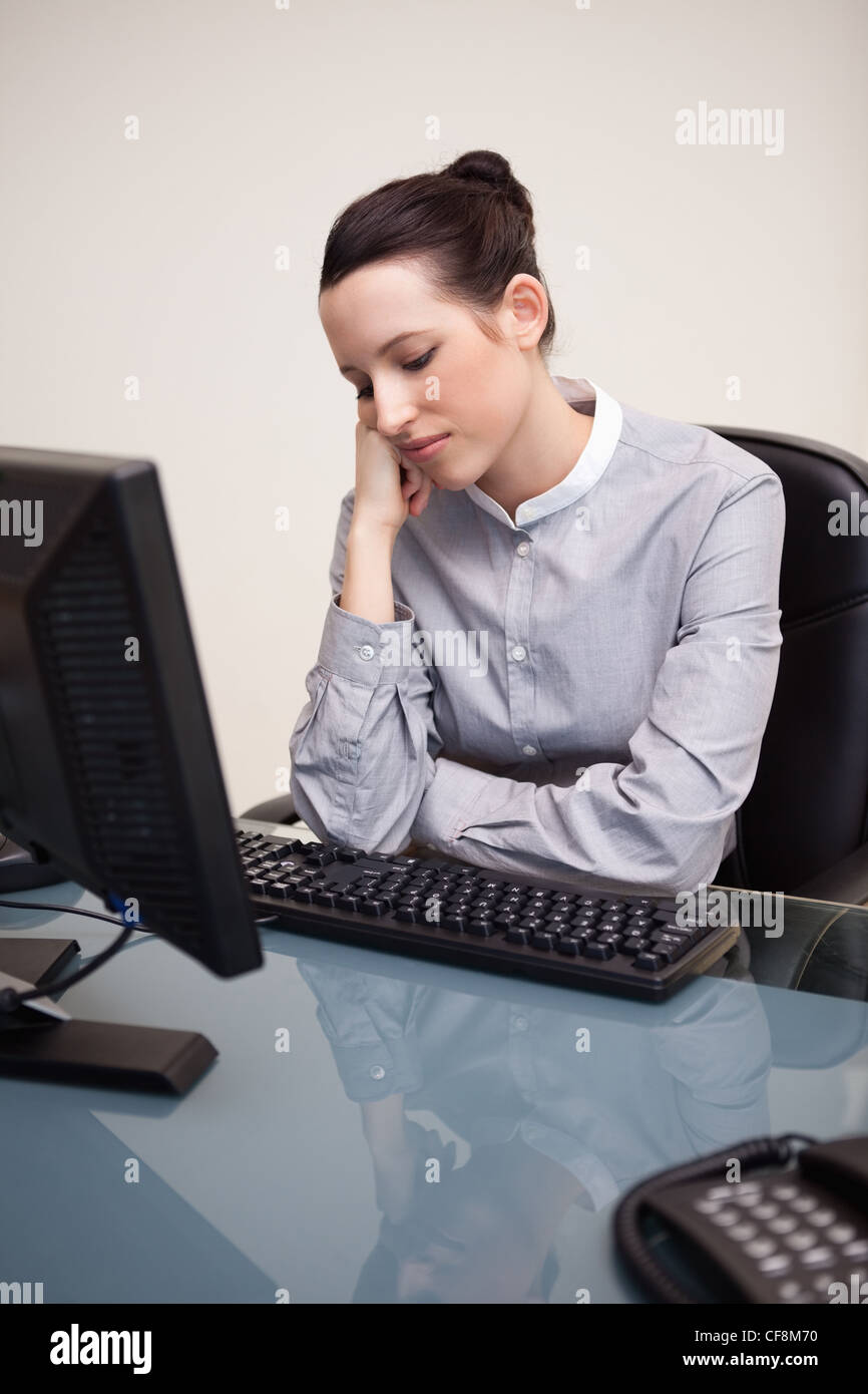 Businesswoman sitting bored at her desk Stock Photo - Alamy