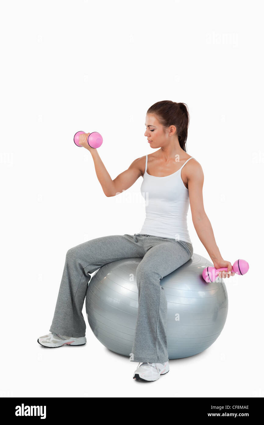 Portrait of a cute woman working out with dumbbells and a ball Stock ...