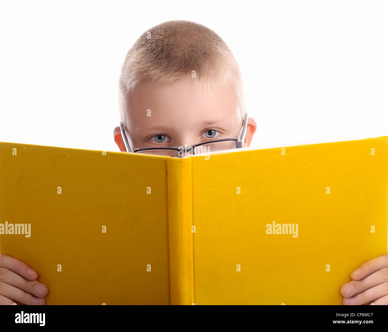 boy looking from behind a yellow book. isolated on white background ...