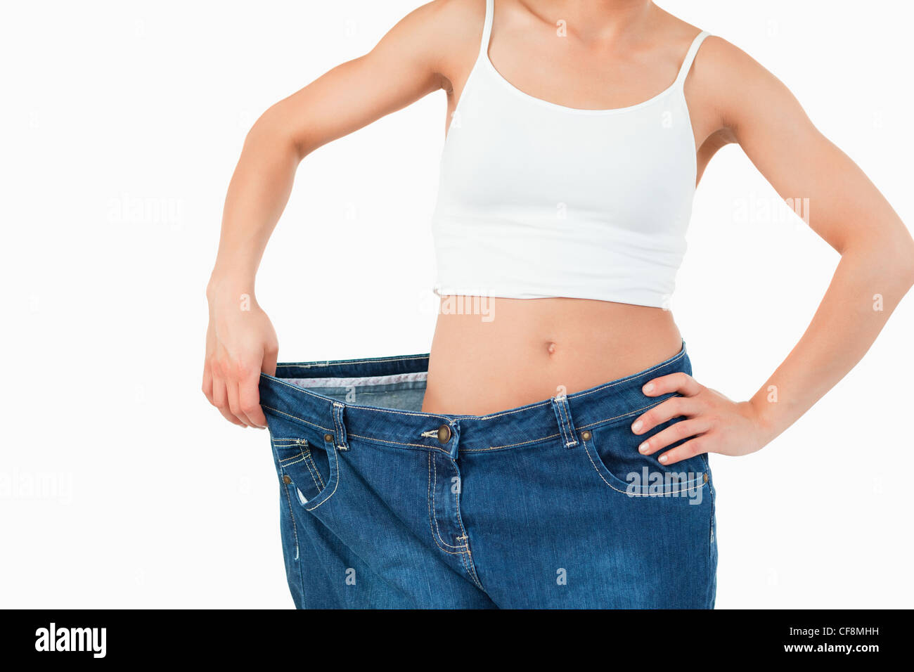Thin woman wearing too large jeans Stock Photo - Alamy