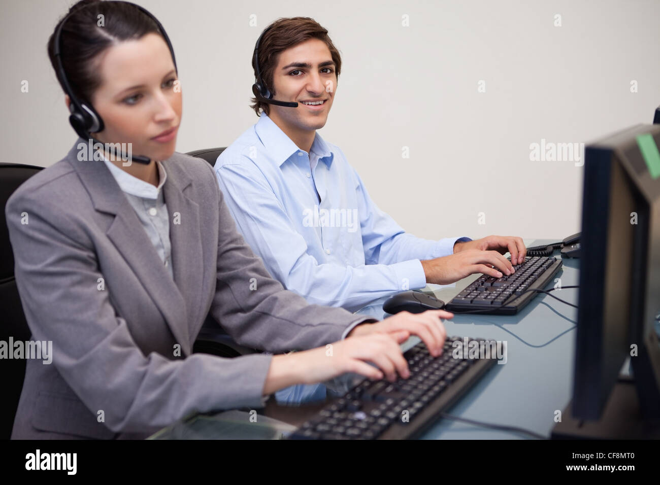 Side view of call center agents working in their office Stock Photo - Alamy