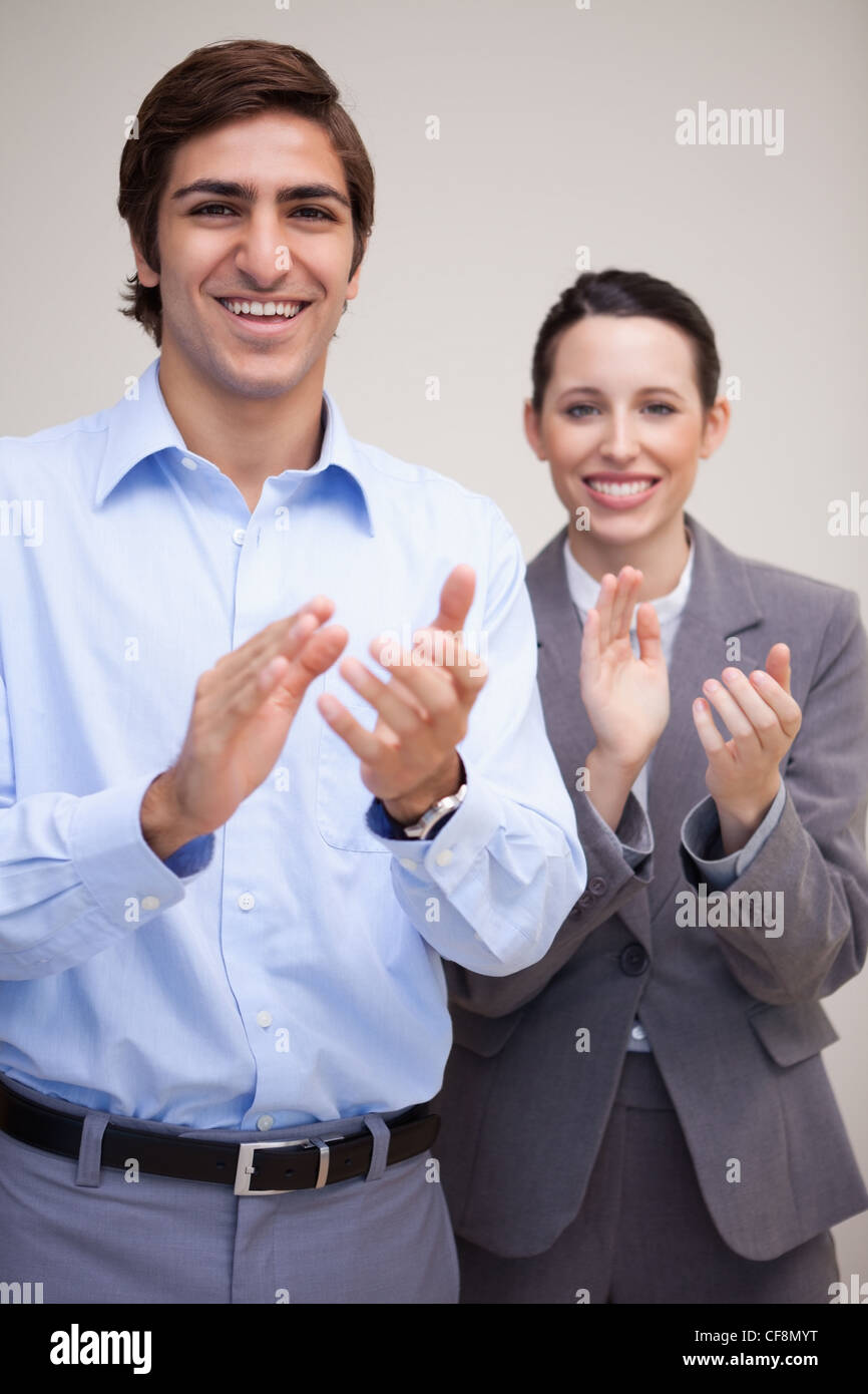 Standing business team clapping Stock Photo - Alamy