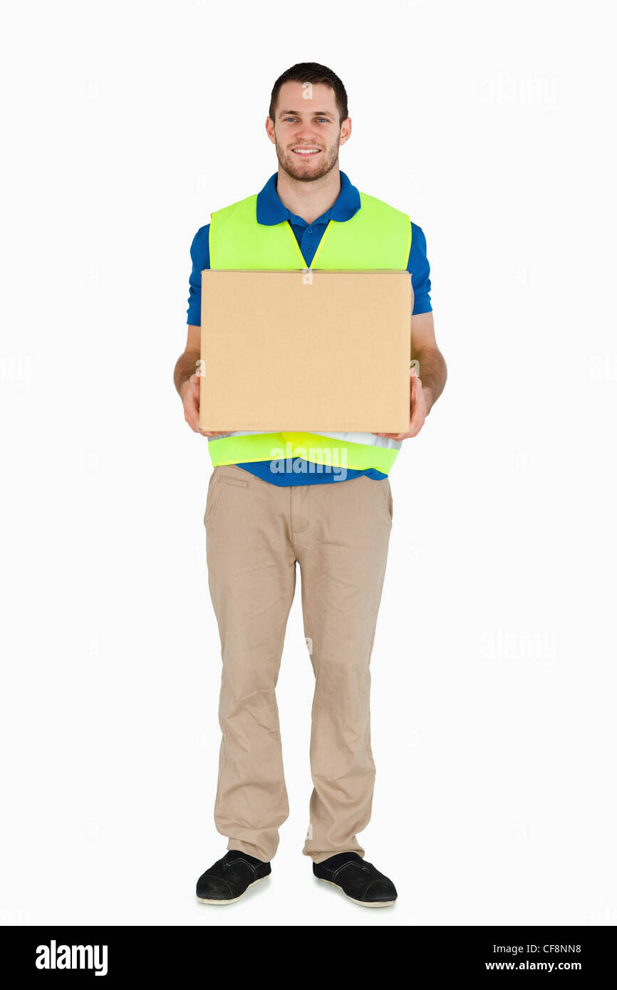 Smiling young delivery man carrying a parcel Stock Photo - Alamy