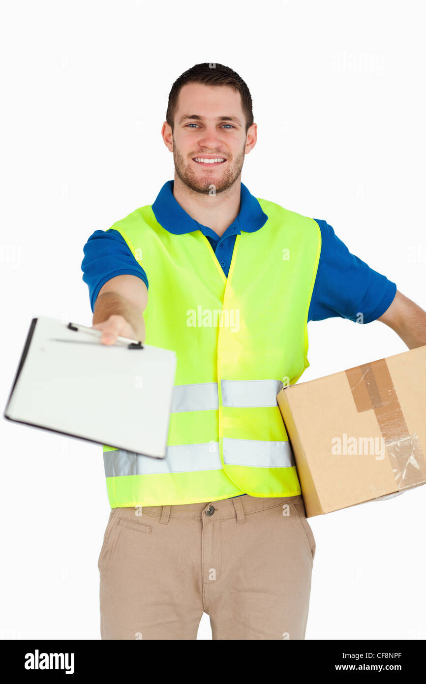 Smiling young delivery man with packet asking for signature Stock Photo ...