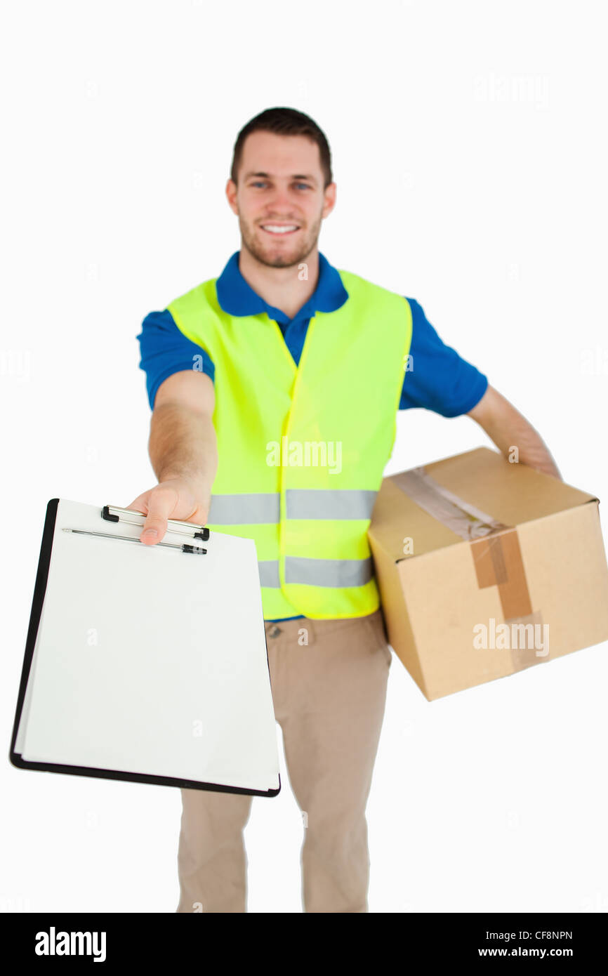 Smiling young delivery man handing over delivery bill for signature ...