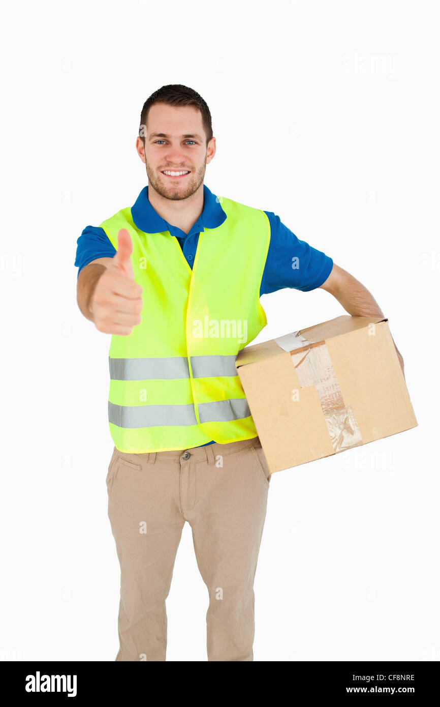 Smiling young delivery man giving approval Stock Photo - Alamy