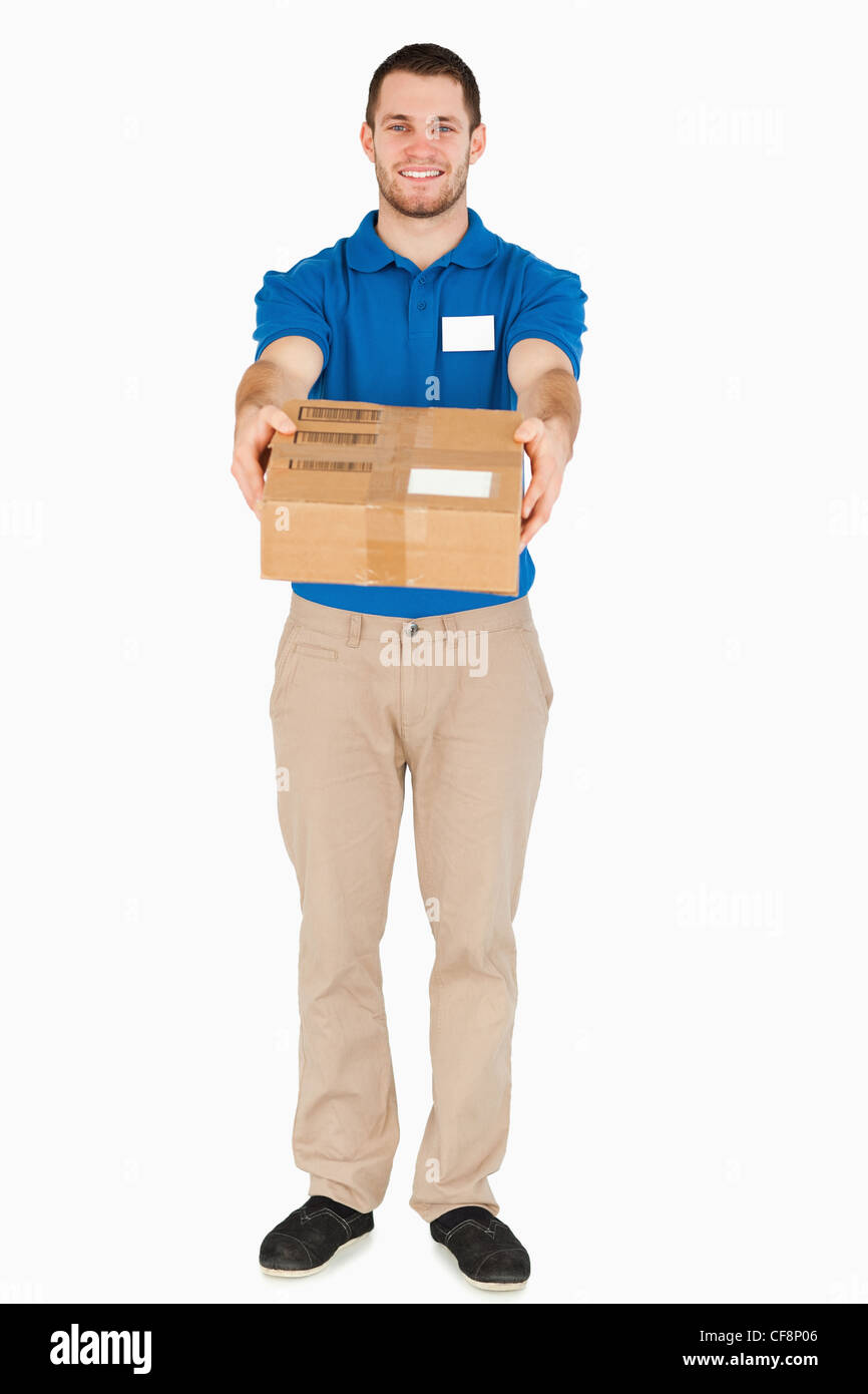 Smiling young salesman handing over parcel Stock Photo - Alamy