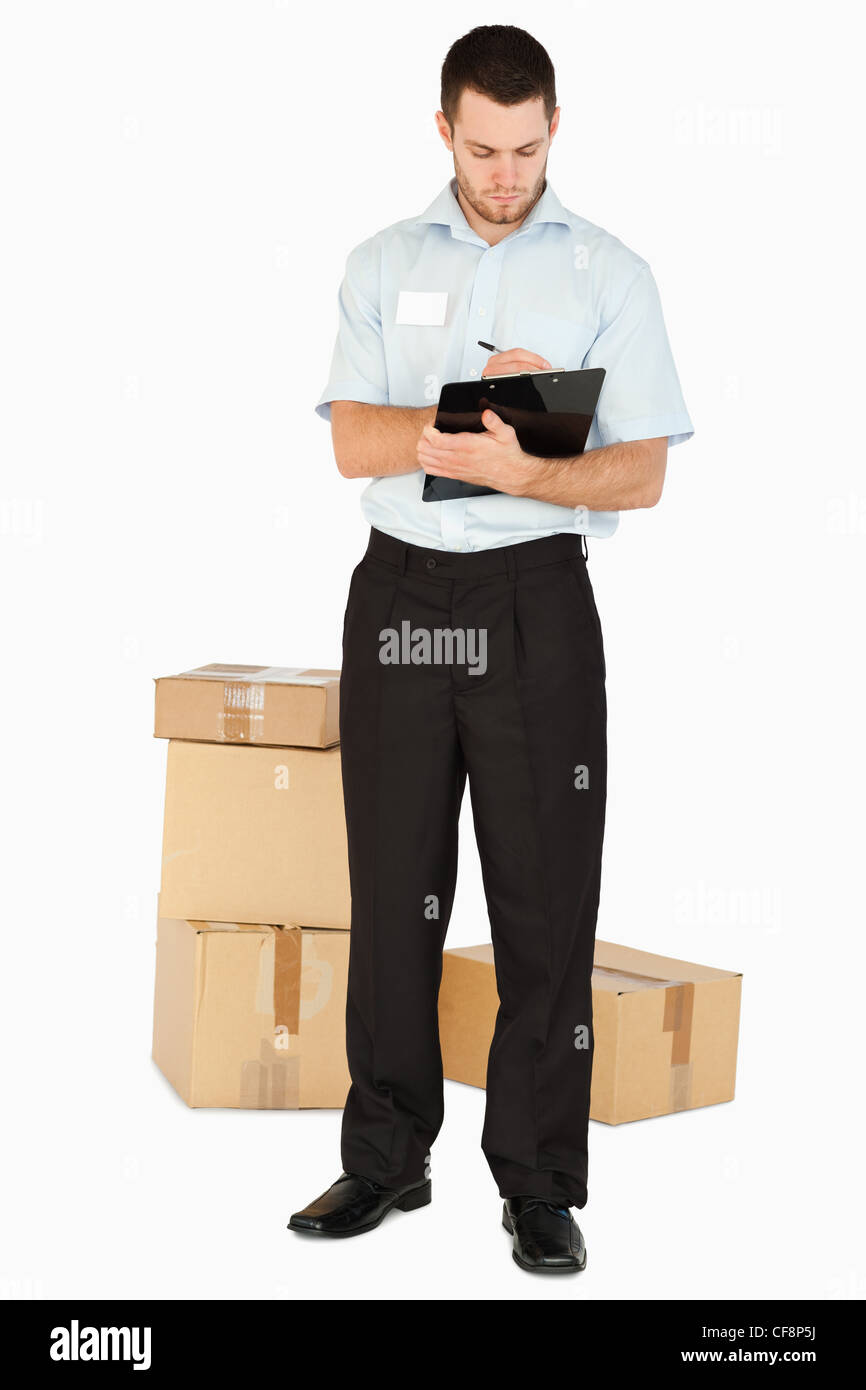Young post employee with parcels taking notes on his clipboard Stock ...