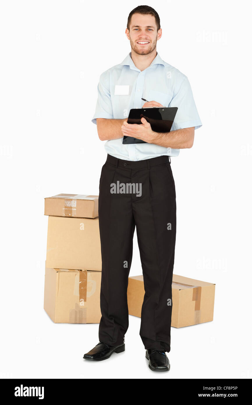 Smiling young post employee with parcels and clipboard Stock Photo - Alamy
