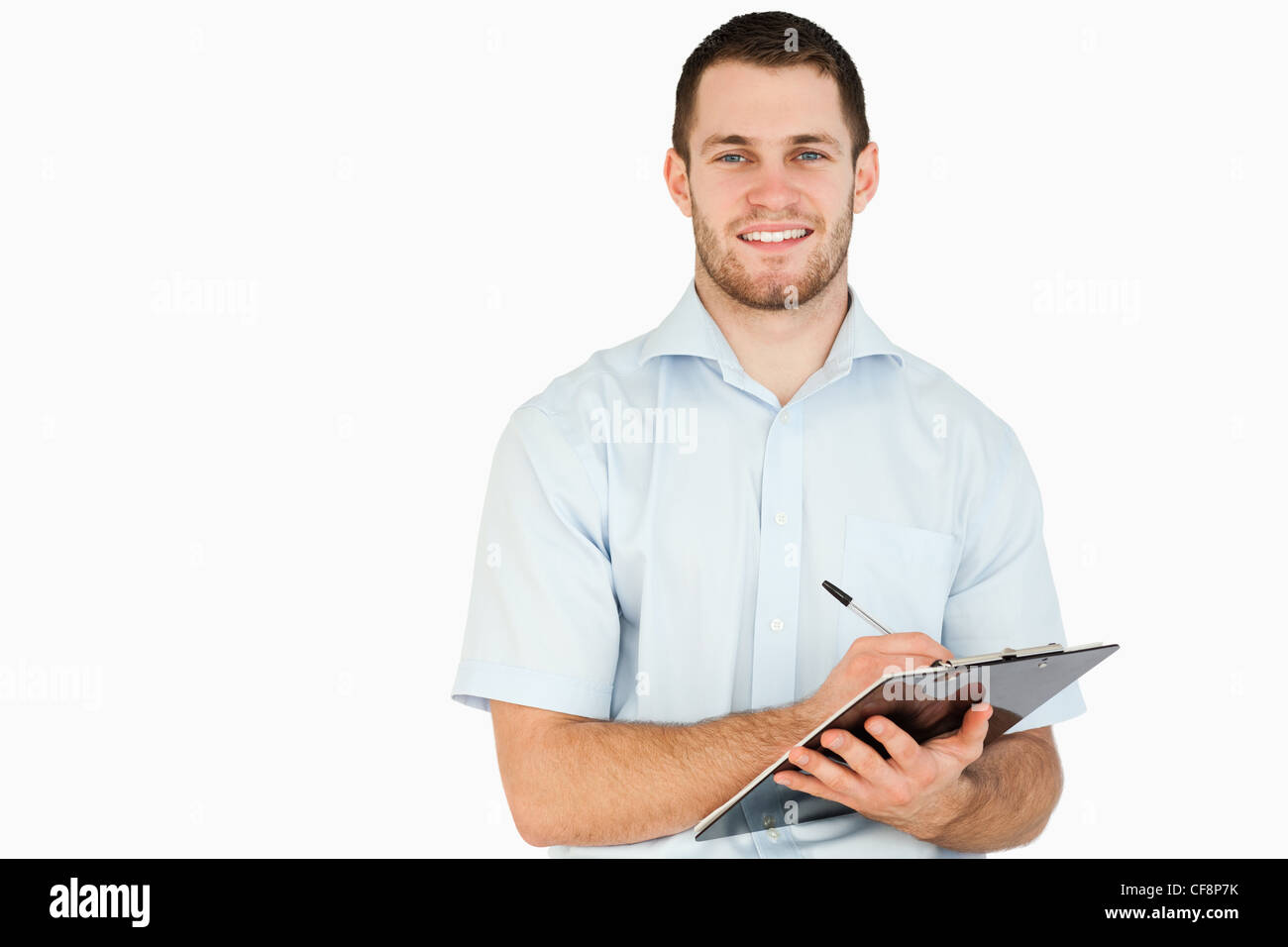 Smiling young post employee taking notes on clipboard Stock Photo - Alamy