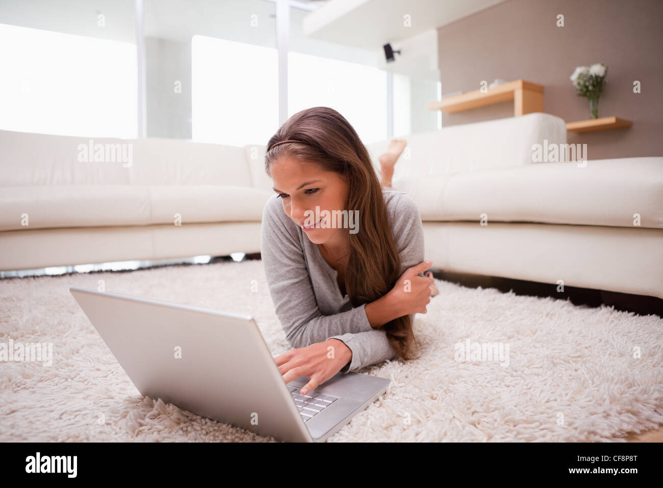 Woman lying with laptop on the floor Stock Photo - Alamy