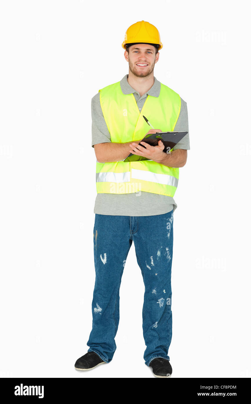 Smiling young construction worker taking notes Stock Photo - Alamy