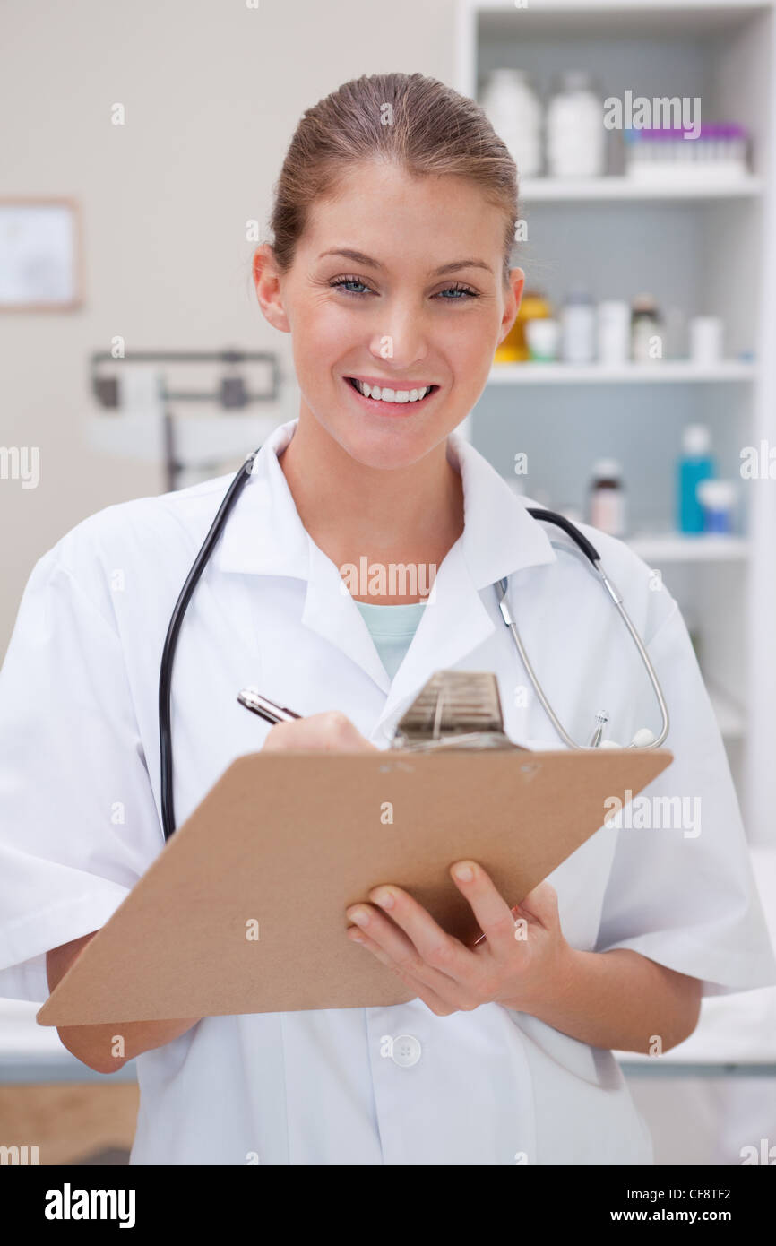 Smiling doctor taking notes on clipboard Stock Photo - Alamy