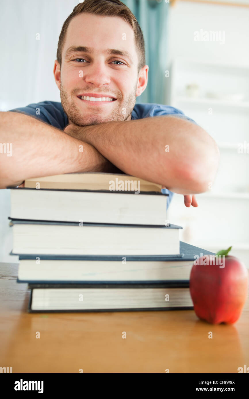 Smiling student with a stack of books Stock Photo - Alamy