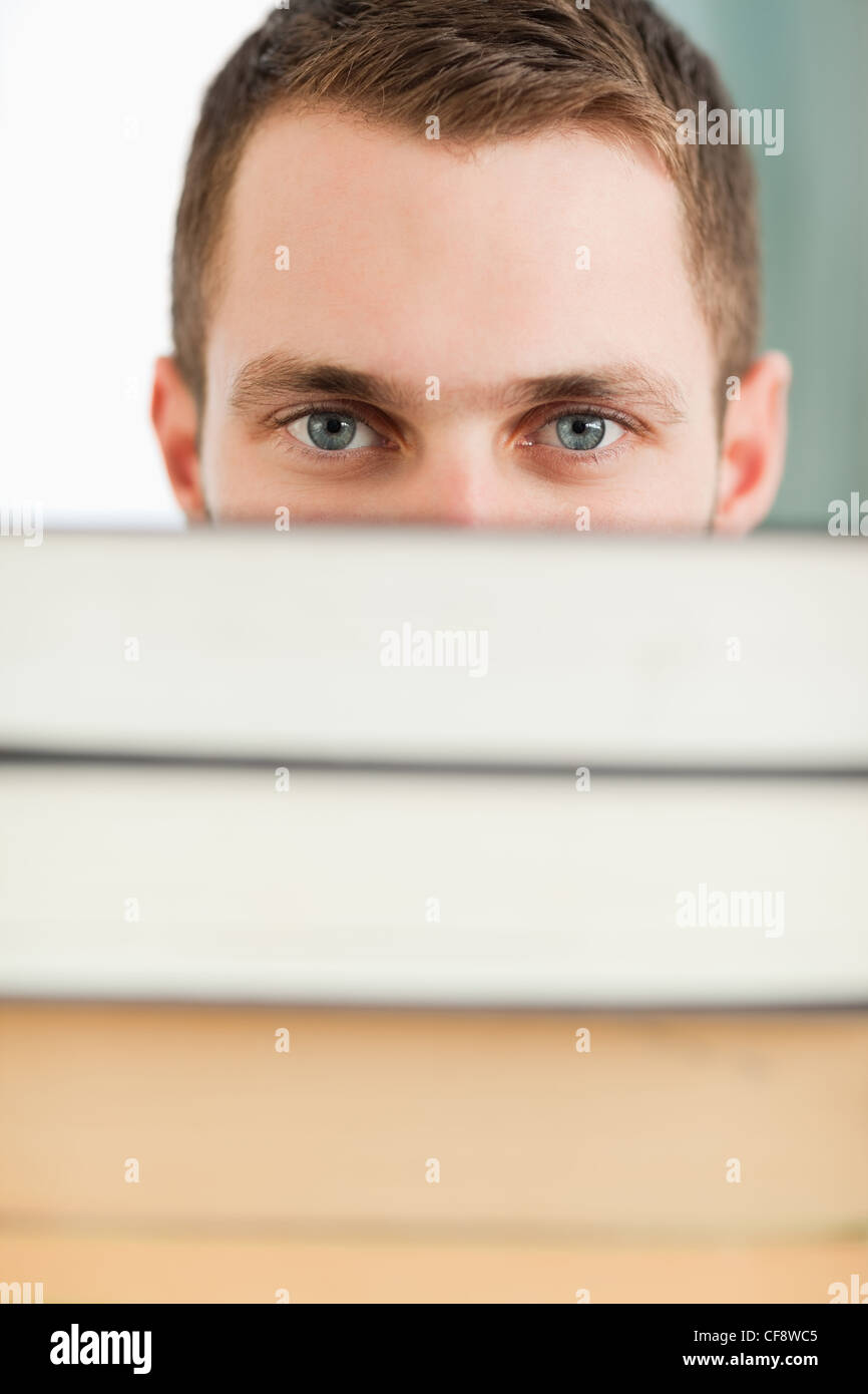 Student behind a pile of books Stock Photo - Alamy