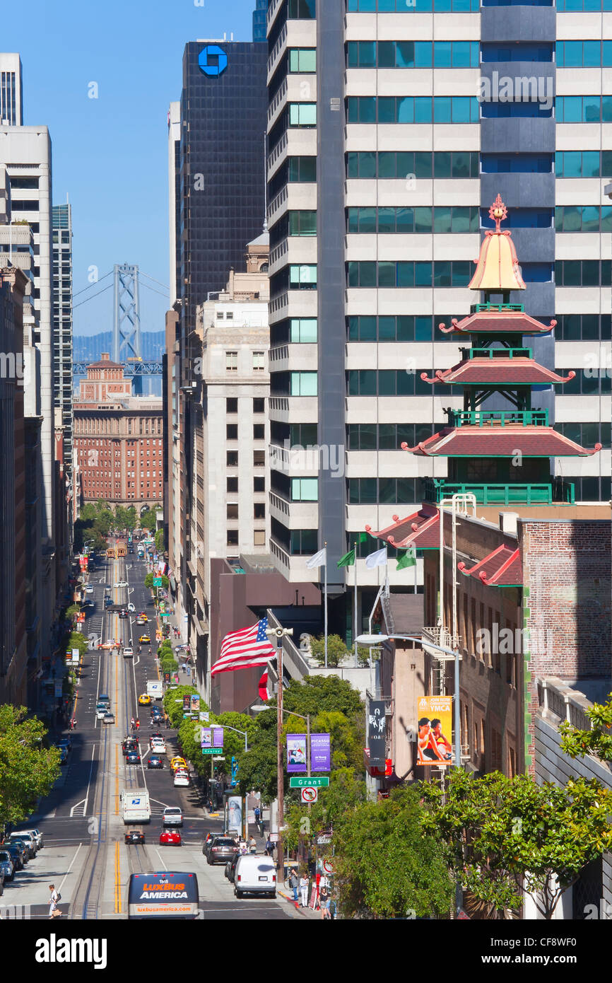 Cable car crossing California Street with Bay Bridge backdrop in San ...