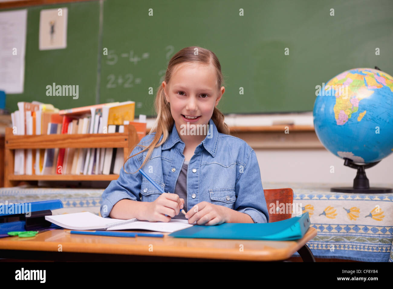 Cute schoolgirl doing classwork Stock Photo - Alamy