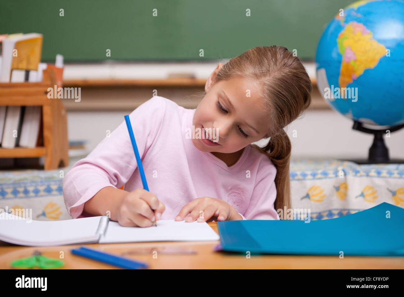Happy schoolgirl writing Stock Photo - Alamy