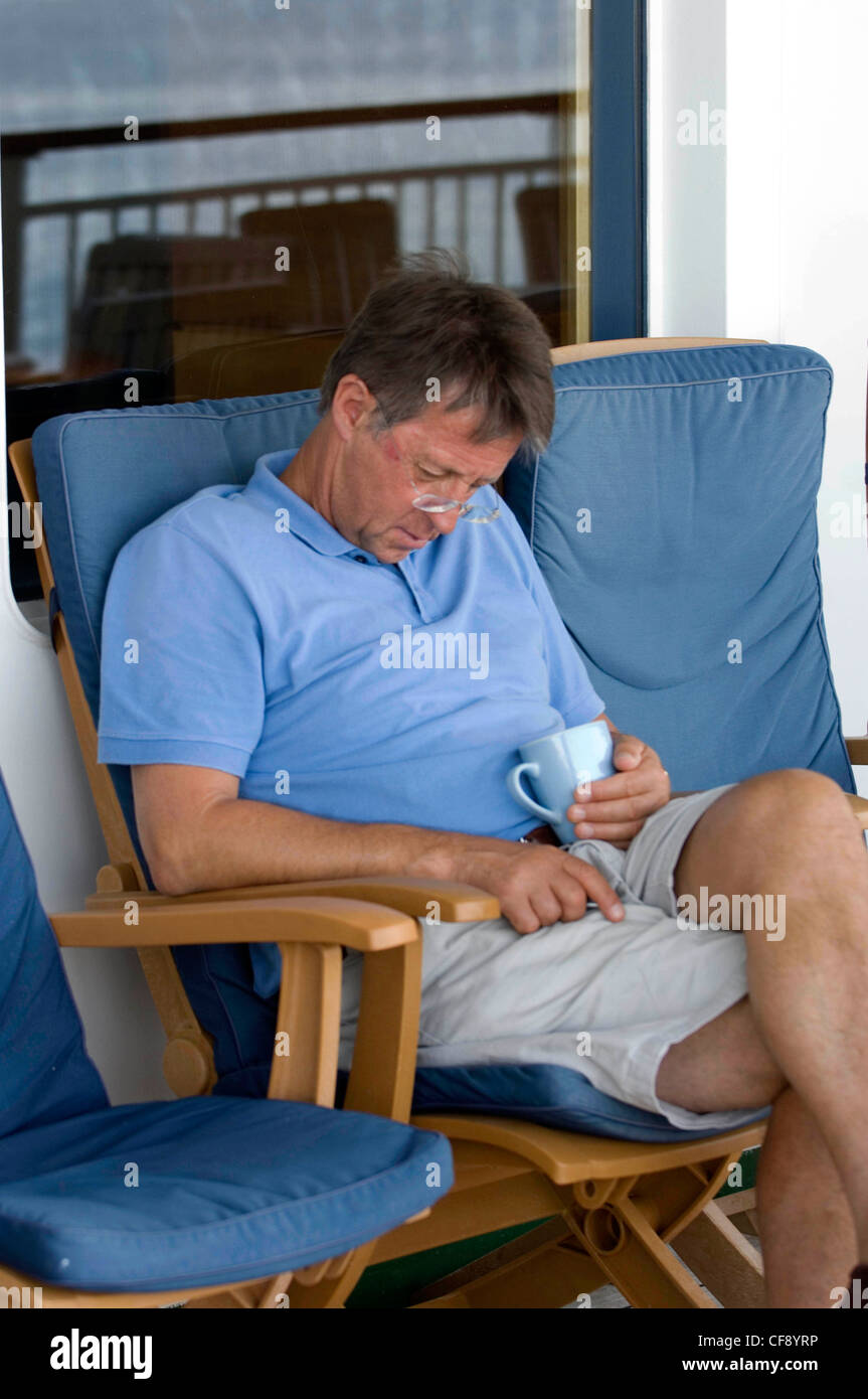 Man having a snooze on board a cruise ship. Editorial use only Stock ...