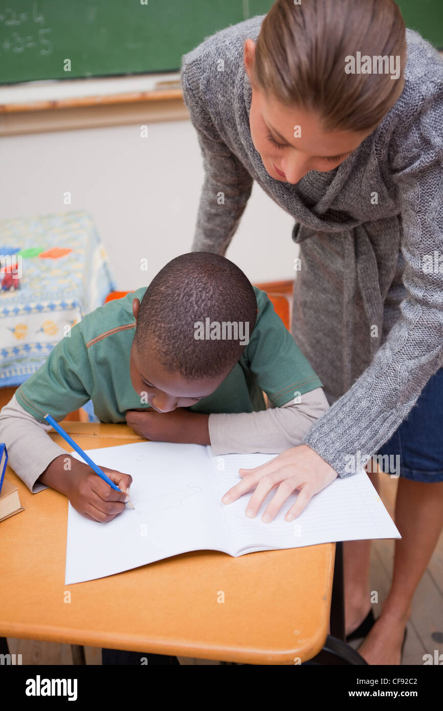 Portrait of a teacher explaining something to a focused schoolboy Stock ...