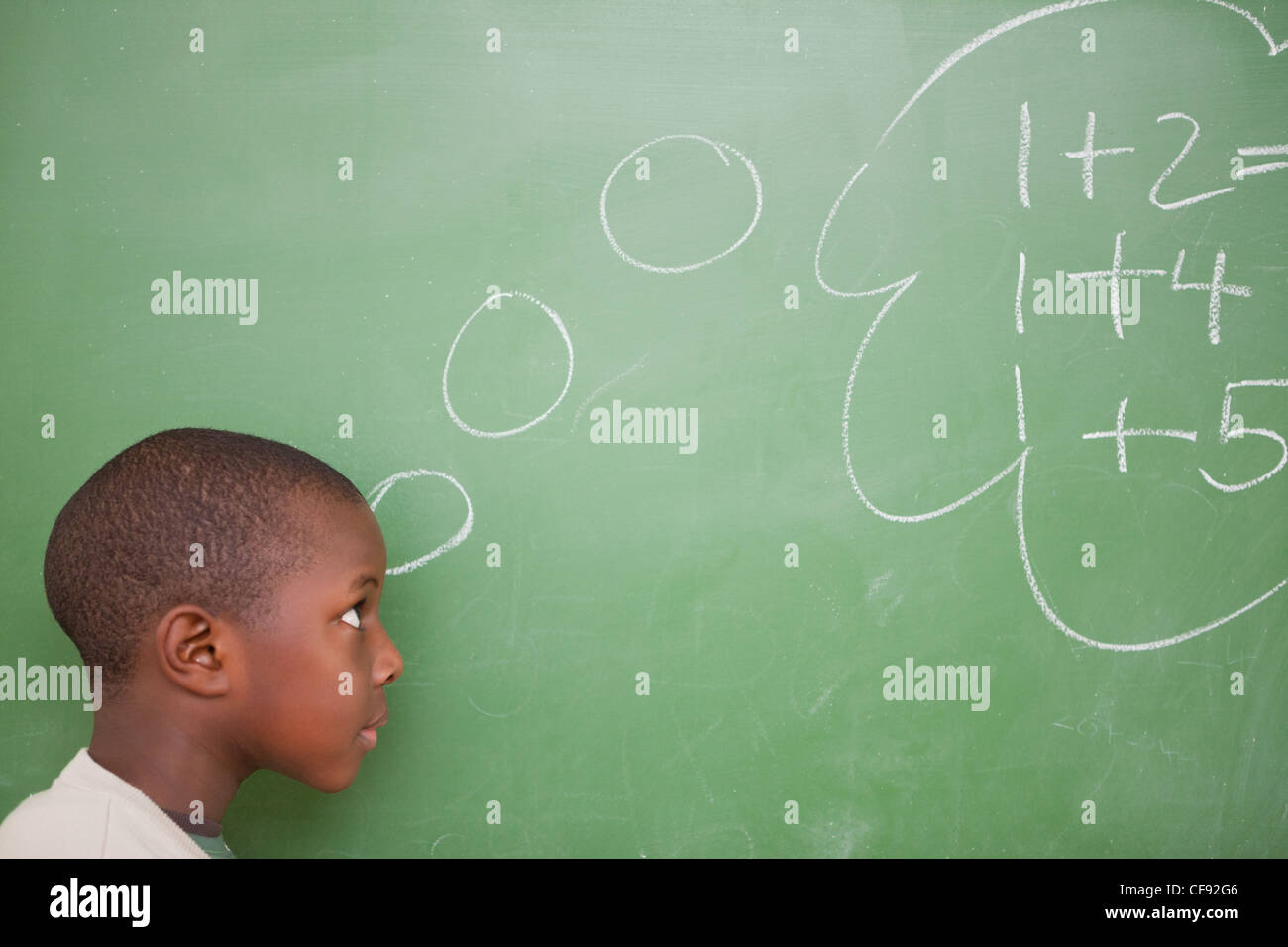 Schoolboy thinking about additions Stock Photo - Alamy